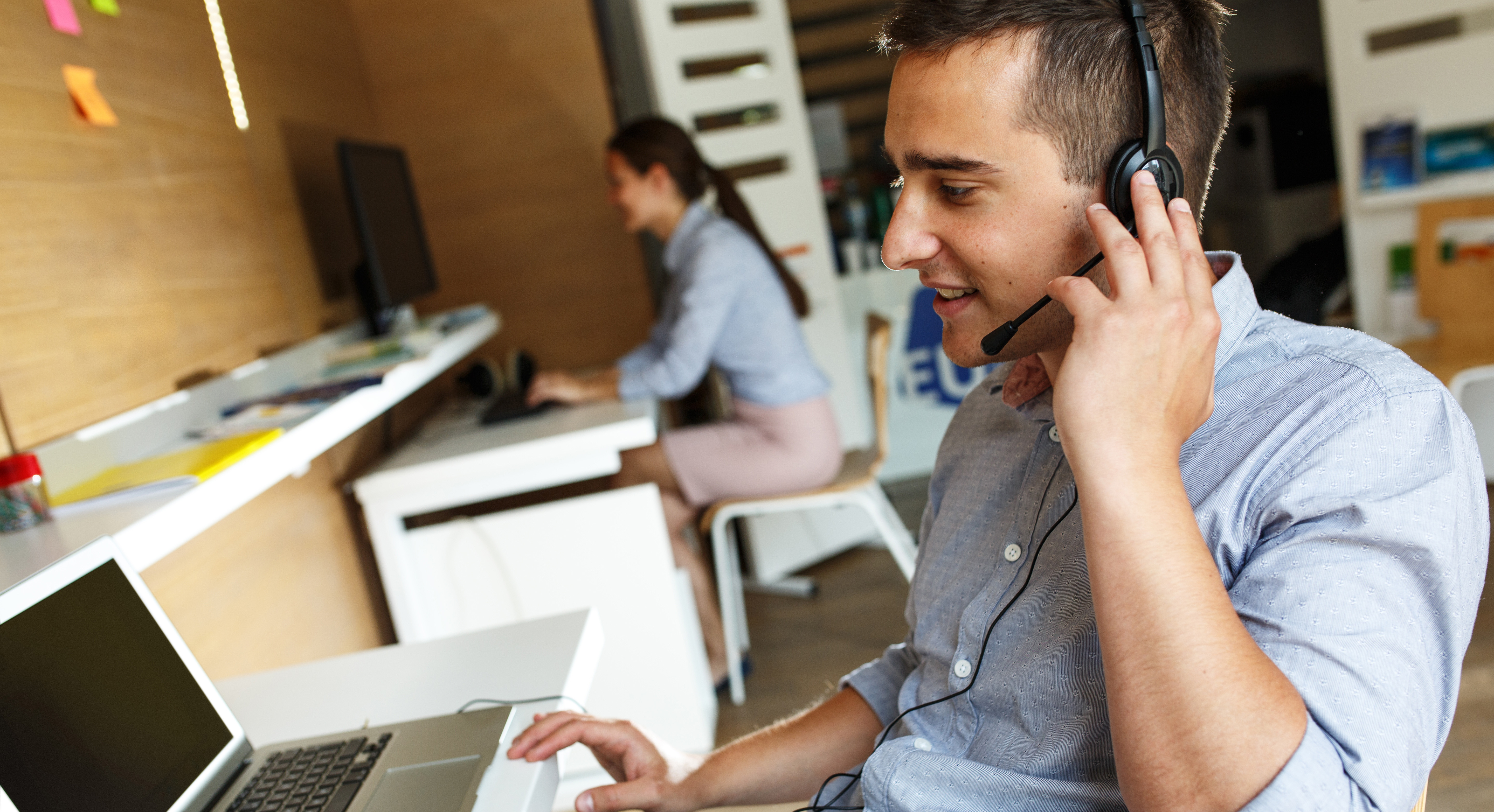 Young man in customer support using laptop and talking with clie | Clearstream Wastewater ...